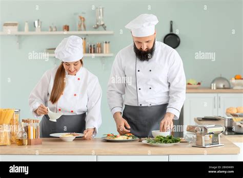 Male And Female Chefs Cooking In Kitchen Stock Photo Alamy