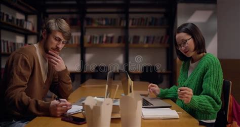 Happy Asian Girl With Glasses Sits Opposite Her Guy Colleague And