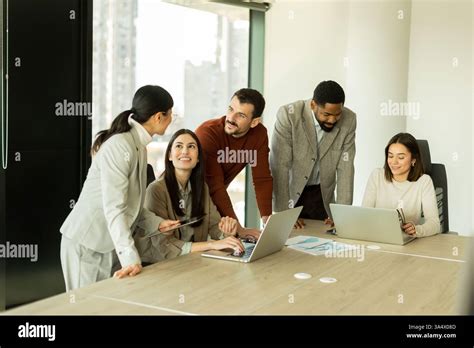 A Diverse Group Of Professionals Collaborates Around A Table In A Sleek