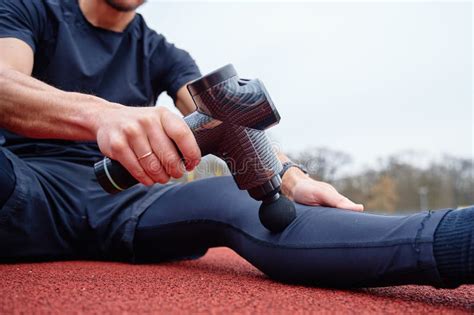 Athlete Using Massage Gun On Leg On Running Track Stock Image Image
