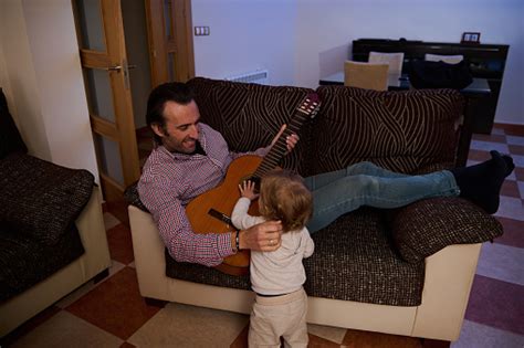 따뜻한 가족 거실 환경에서 어린 아이와 함께 기타를 연주하는 아버지 12 17 개월에 대한 스톡 사진 및 기타 이미지 12 17 개월 2명 40 44세 Istock