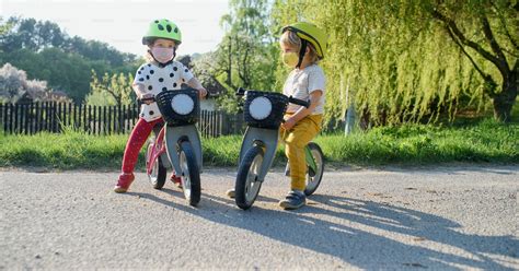 얼굴 마스크를 쓴 어린 소년과 소녀는 자전거 코로나바이러스 개념으로 야외에서 놀고 있습니다 사진 Unsplash의 슬로바키아 이미지