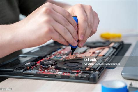 한 남자가 먼지를 불기위한 특별한 도구로 노트북을 청소합니다 노트북 냉각 시스템의 쿨러에 먼지 수리 및 서비스 노트북 및 Pc Cpu에 대한 스톡 사진 및 기타 이미지