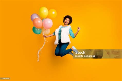 전체 길이 사진 펑키 미친 미국 여자 점프 풍선 승리 이벤트 비명 예 제기 주먹을 착용 흰색 청록색 세련된 트렌디 한 스웨터 블루 바지 바지 고립 밝은 색상 배경 풍선에