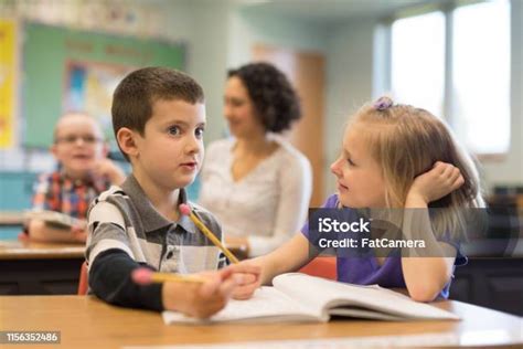Two Young Elementary School Students Working Together On An Assignment