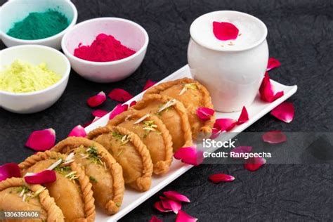 데시 기 피스타 바담에서 만든 구지야 또는 구지아 미타이는 해피 홀리를 계기로 차가운 탄다이 황과 함께 봉사했다 복사 공간이있는 검은 배경에 다채로운 Gulal Abeer