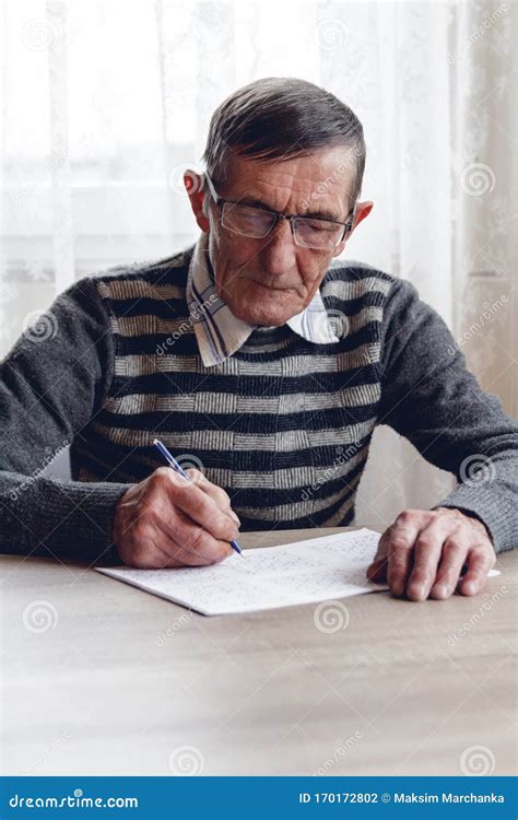 Senior Solves Sudoku Or A Crossword Puzzle To Slow The Progressi Stock