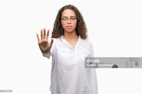 아름 다운 젊은 히스패닉 여자 손의 종 려를 가진 정지 노래를 하 고 얼굴에 부정적이 고 심각한 제스처와 경고 식입니다 거절에