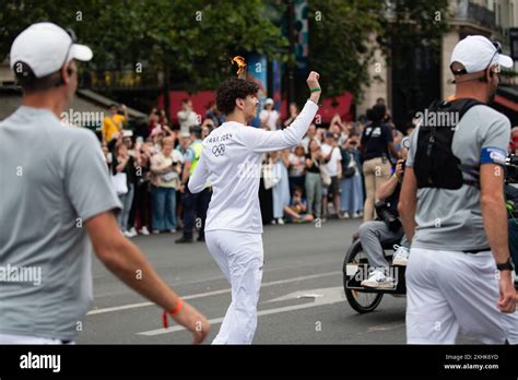Paris France 14th July 2024 A Torch Bearer Waves At The Onlookers