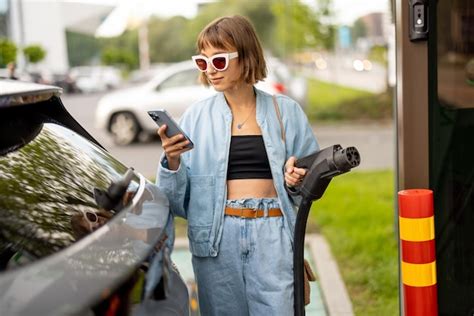 Premium Photo Woman On Charging Station For Electric Cars
