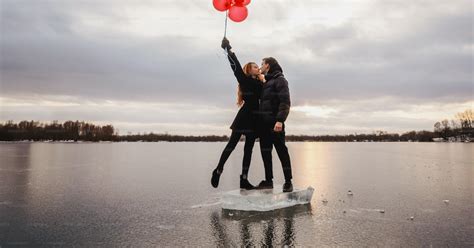 빨간 풍선을 가진 사랑 커플은 하늘과 얼음 강 배경에 야외에서 키스한다 일몰 조명 블랙 캐주얼 의류 사진 Unsplash의 자연 이미지