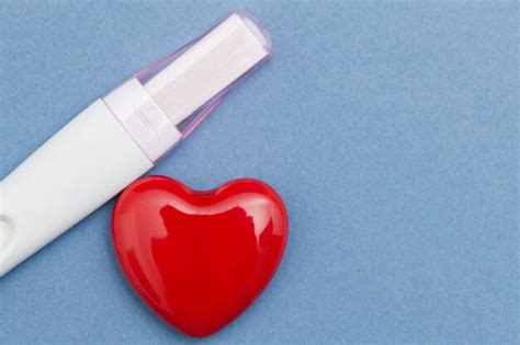 Premium Photo Pregnancy Test With A Red Heart On A Blue Background