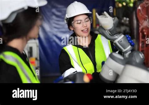 Professional Engineers Working With Machine Robotic Arms At Industrial Factory Technicians