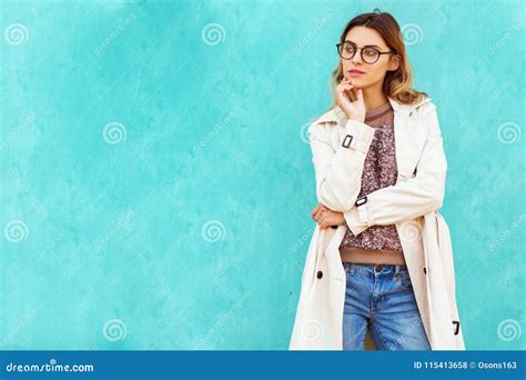 Fashion Girl In Round Glasses Stands Posing Near A Turquoise Wall Stock