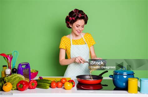 사진 긍정적 인 소녀는 생태 채식 맛있는 저녁 식사 프라이팬 슬라이스 강판 치즈를 준비 토마토 후추 성분이 노란색 점선 티셔츠 헤어 롤러 고립 녹색 색상 배경을 착용 갈색