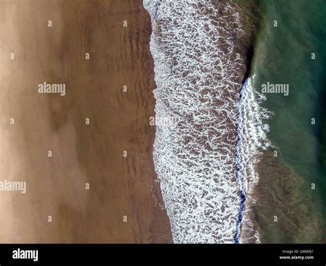 Looking Down From Above At Waves Washing Up On Sandy Beach Ocean Water