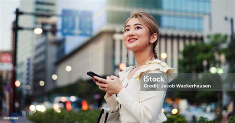 행복한 전화와 일본 여성은 도쿄의 위치 거리 도로 또는 휴가 모험 여행에 도시에서 야간 보도 또는 미소가 있는 여성 관광객 또는 여행 여행 내비게이션 또는지도를 위한 모바일