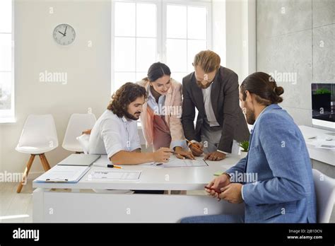 Colleagues In The Office Work Together On A Business Project Comparing