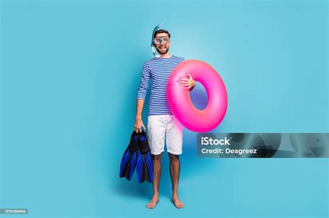재미 흥분 남자 관광 수영 홀드 수중 마스크 호흡 튜브 플리퍼 핑크 구명 부이 착용 줄무늬 선원 셔츠 반바지 고립 된 블루 컬러 배경의 전신 사진 남자에 대한 스톡 사진 및