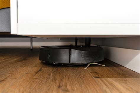 현대적인 로봇 진공 청소기는 자율 청소 로봇인 침실 가구 아래 비닐 패널을 청소합니다 0명에 대한 스톡 사진 및 기타 이미지