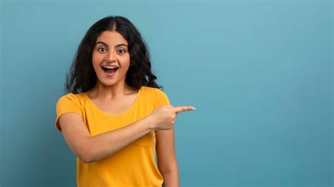 premium photo excited woman pointing outside of frame