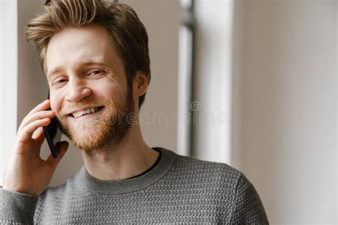 Ginger Young Man Talking On Mobile Phone While Standing Stock Image