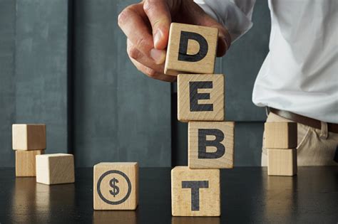 빚이라는 단어와 달러의 이미지가 있는 나무 블록 국가에 대한 세금 및 부채 지불 금융 위기와 문제의 개념 리스크 관리 부채 면제 0명에 대한 스톡 사진 및 기타 이미지