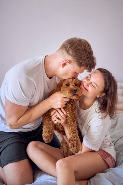Premium Photo A Couple Gently Hugs And Kisses A Cockapoo Girl Minimalism