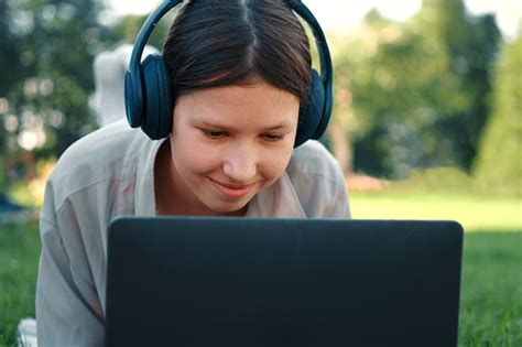 십대 여학생은 야외에 앉아 책 태블릿 공책을 읽고 공부하고 있다 학교로 돌아 가기 대학 운동장이나 공원에서 노트북을 사용하여