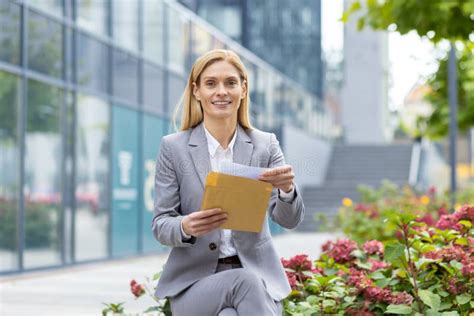 Professional Businesswoman Holding Documents Outdoors In A Modern Urban Environment Stock Image