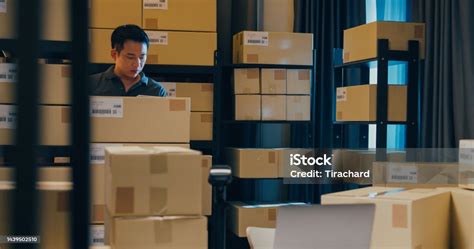 아시아 사업가는 선반에있는 바코드 스캐너 스캔 종이 상자를 사용하고 창고에서 신속한 배달을 위해 디지털 태블릿 컷 재고 온라인