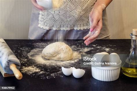유리 그릇에서 밀가루를 추가 하 여 검은 나무 테이블에 여성 손으로 반죽을 만들기 반죽 계란 식물성 기름 밀가루 테이블 대리석에 대 한 재료는 반죽에 대 한 롤 건강 한