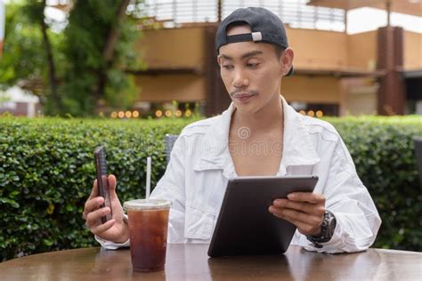 Cute Non Binary Gay Man Drinking Coffee In Outdoors Cafe Restaurant