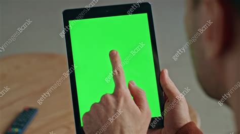 Guy finger touching greenscreen tablet at office room. Man using chroma ...