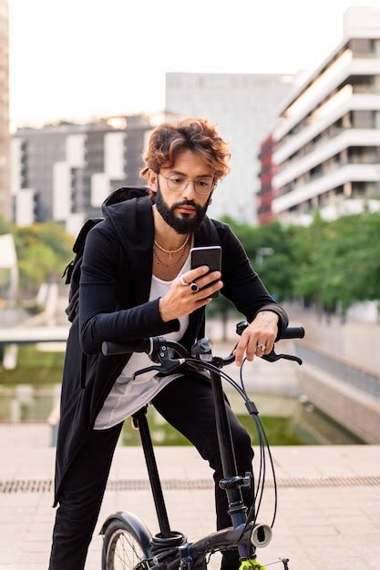Premium Photo Man Using Mobile Phone While Sitting On His Bike
