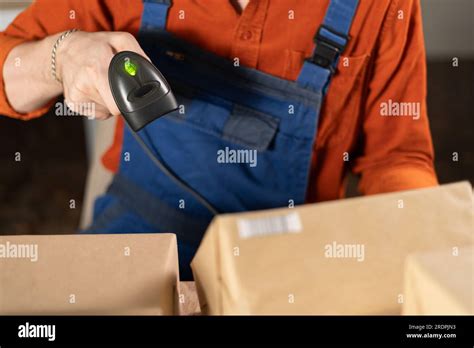 Scanning Barcode On Delivery Parcel Worker Hands Scan Barcode Of Cardboard Packages Man In