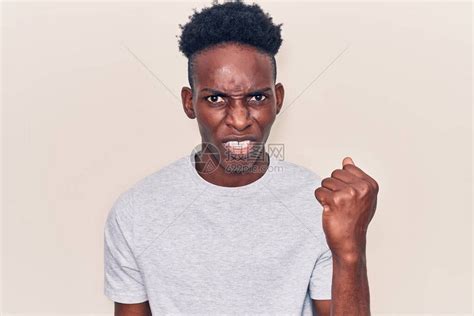 身着散装衣的非洲青年男子愤怒而疯狂地举起拳头感到沮丧和愤怒高清图片下载 正版图片503840978 摄图网