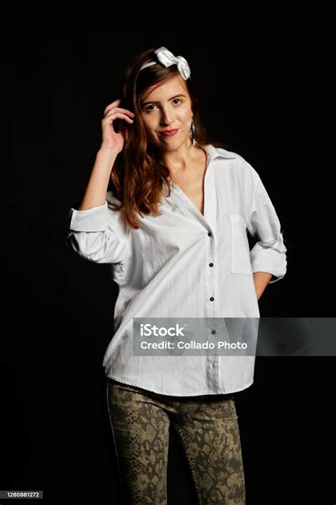 젊은 갈색 머리 스페인 여자 옷을 입고 청소년 옷 후프 귀걸이 그리고 검은 배경에 흰색 활머리 20 24세에 대한 스톡 사진 및