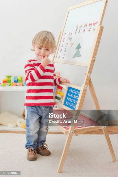 귀여운 어린 아이가 자기 판에서 놀고 집에서 편지 숫자 및 기하학적 모양을 학습합니다 초기 개발을위한 교육적이고 재미있는 실내 활동 2 3 살에 대한 스톡 사진 및 기타