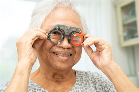 Asian Senior Woman Wearing Ophthalmic Vision Eye Test And Using Optical Trial Frame Stock Image