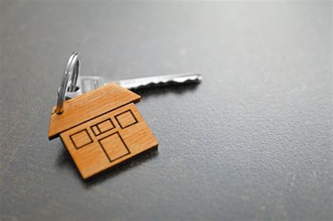 Premium Photo Key With Trinket In Shape Of House On Dark Table