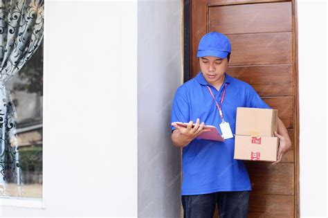 Premium Photo Deliveryman In Blue Uniform Holding Box And Clipboard