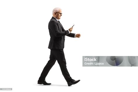 휴대 전화를 사용하여 걷고 있는 성숙한 전문 남자의 전체 길이 프로필 샷 걷기에 대한 스톡 사진 및 기타 이미지 걷기 컷아웃 남자 Istock