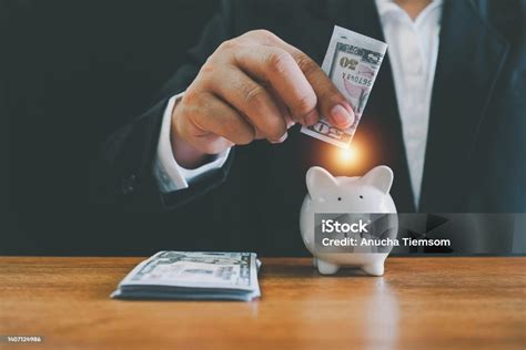 에너지 절약 및 비용 개념 돈 금융을 계획하기 위해 책상에 쌓여있는 동전 개념 저축 및 금융 계좌 개념 나무 테이블에 돼지 저금통이있는 동전으로 돈을 절약하십시오 개념에