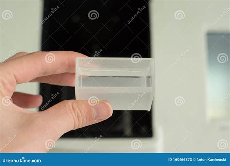 Cuvette For A Spectrophotometer In The Hands Of A Scientist Against