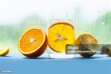 기체 물과 거품투명 유리와 오렌지 내부의 둥근 조각 그 옆에 반 육즙과 잘 익은 오렌지와 레몬 배경에 물에서 방울과 얼룩유리 감귤류 과일에 대한 스톡 사진 및 기타 이미지