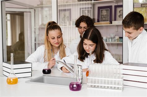 학교 교육 화학 수업에서 쾌활한 급우들은 실험을 위해 액체가 든 플라스크를 들고 있습니다 행복한 친구들은 실험실에서 함께 공부합니다 12 13세에 대한 스톡 사진 및 기타