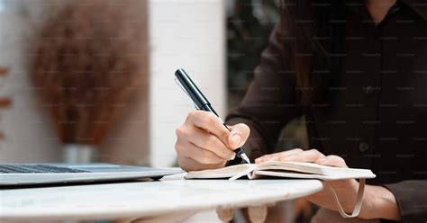 노트북 컴퓨터로 작업하고 노트북에 메모를 쓰는 젊은 여성 프리랜서의 자른 사진 사진 Unsplash의 태국 이미지