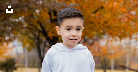 흰 후드티를 입은 어린 소년이 보도에 서 있다 사진 Unsplash의 무료 초상 이미지