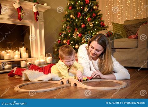 Mamman Och Sonen Som Spelar Med En Leksak Utbildar Arkivfoto Bild Av Garnering Helgdagsafton